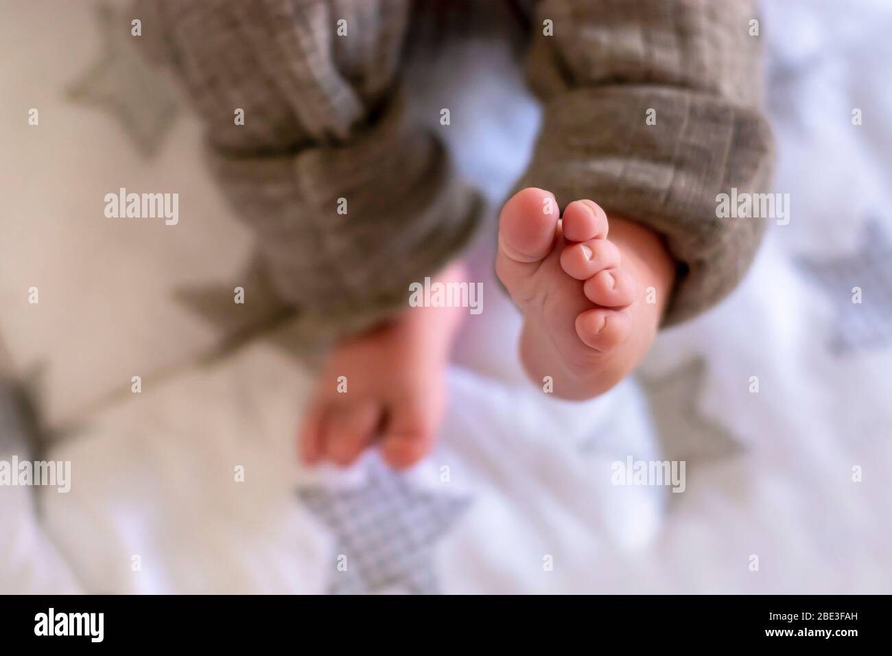 Newborn baby feet and tiny toes. View from above. Box sheet with star ...