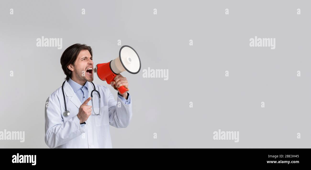 Stressed male doctor emotionally screaming at copy space with ...