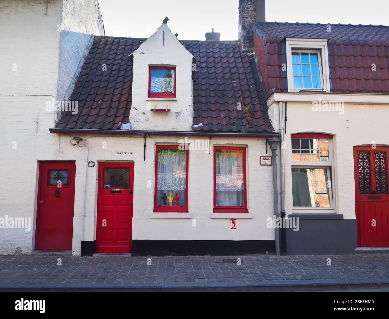 Typical Flemish house in white bricks and red windows and door in ...