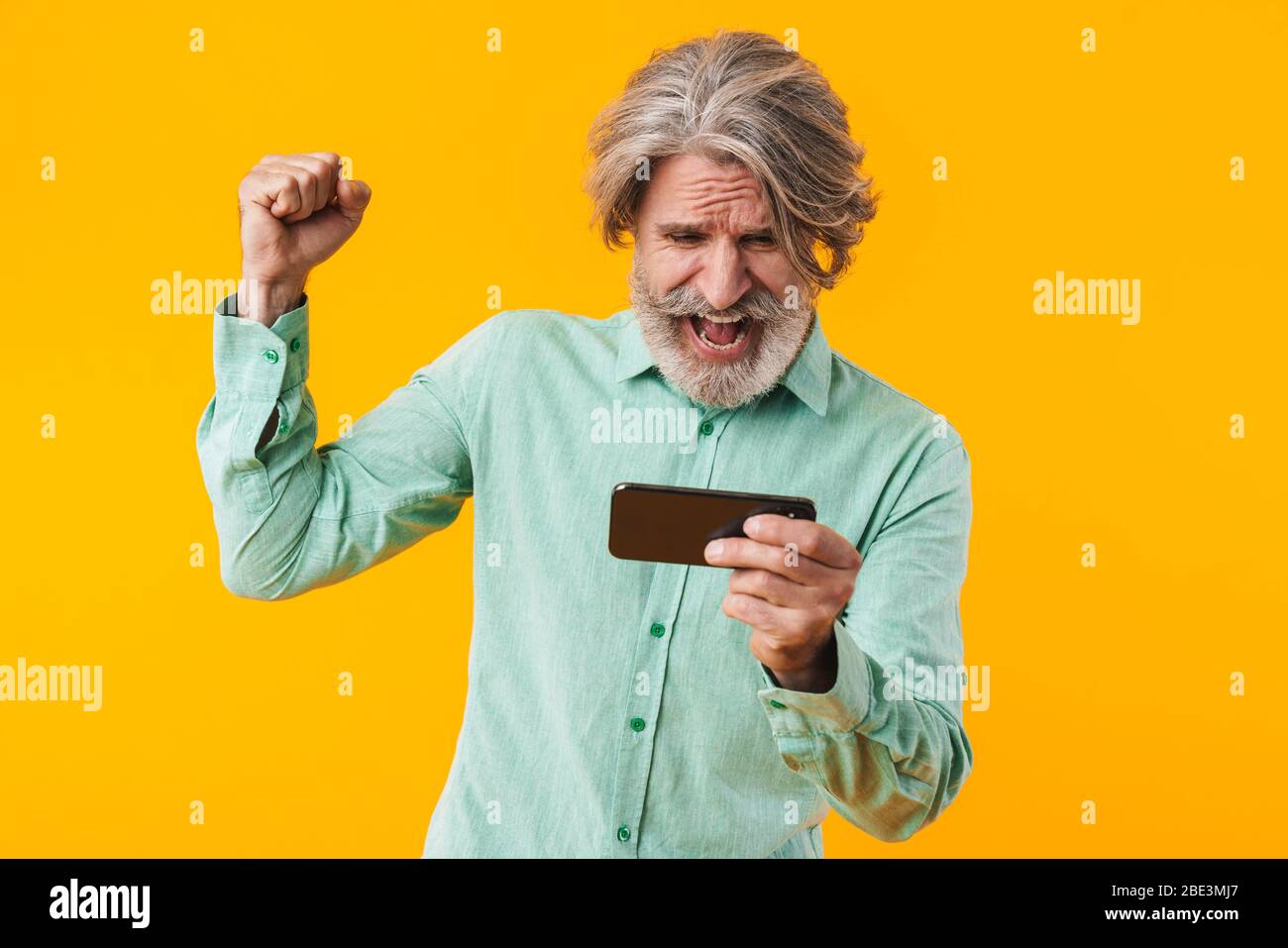 Image of screaming grey-haired bearded man in blue shirt posing ...