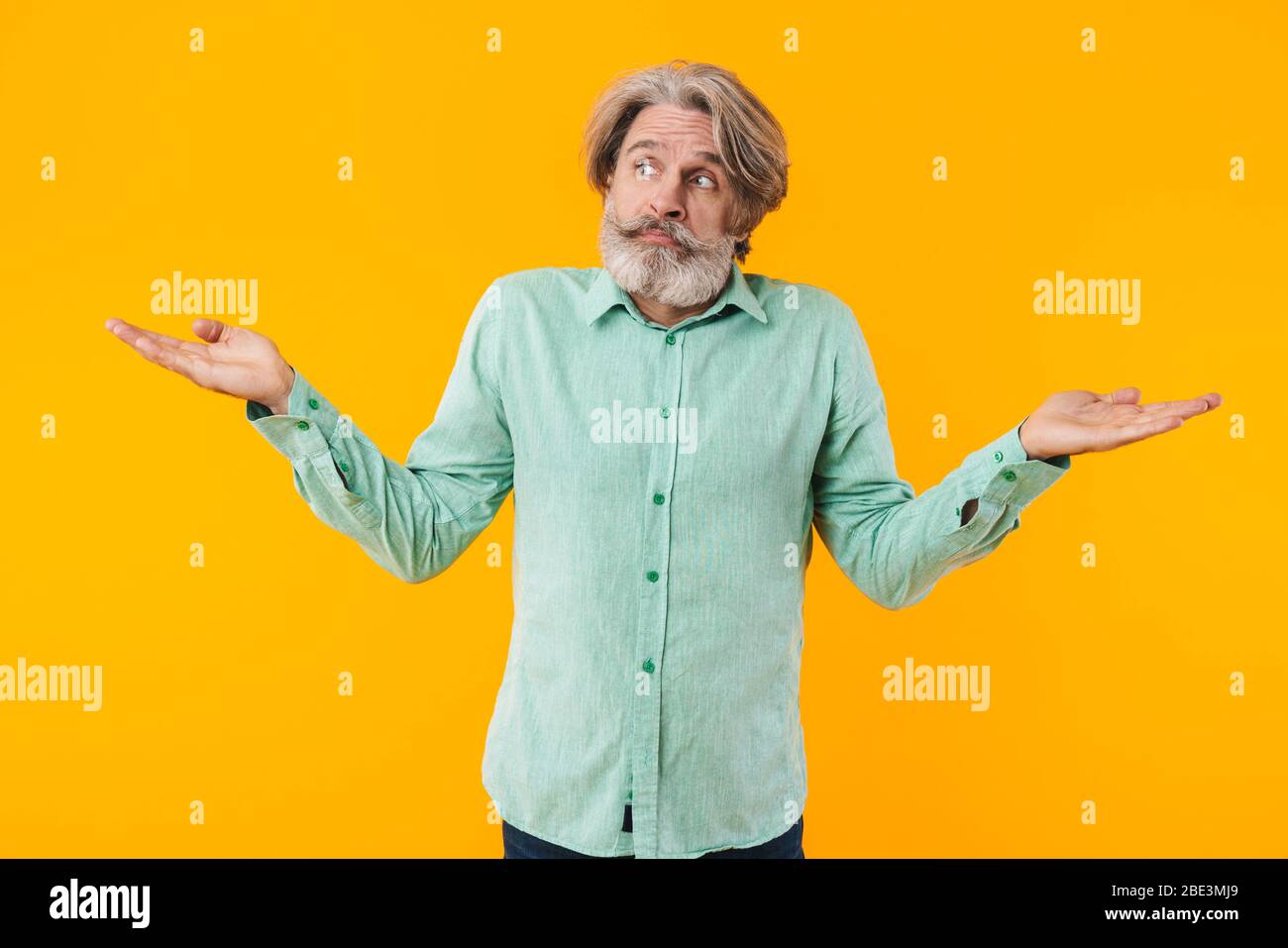 Image of confused elderly grey-haired bearded man in blue shirt posing ...