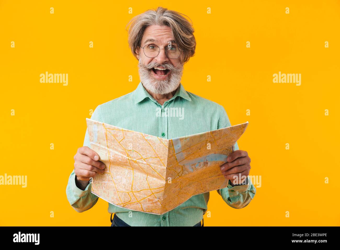 Picture of surprised happy grey-haired man posing isolated over yellow ...
