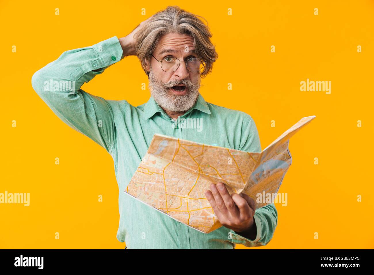 Picture of shocked confused grey-haired man posing isolated over yellow ...