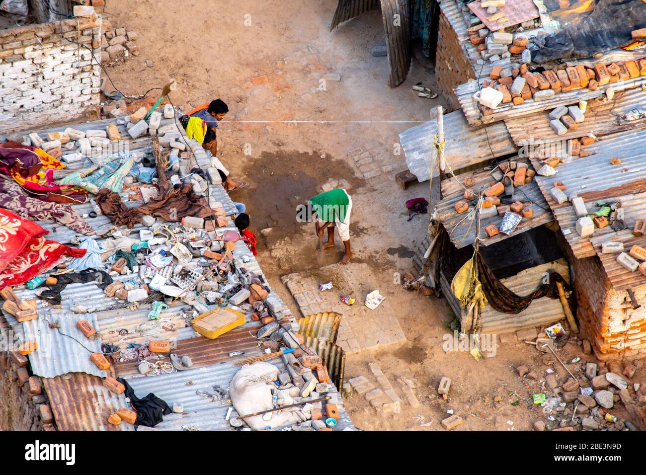 Aerial shot of young boy cleaning up the dirt path between the brick ...