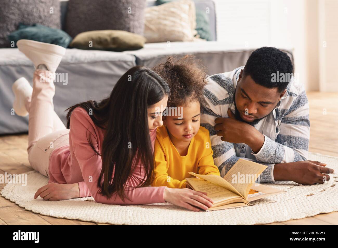 Reading lessons in an international family at home Stock Photo - Alamy