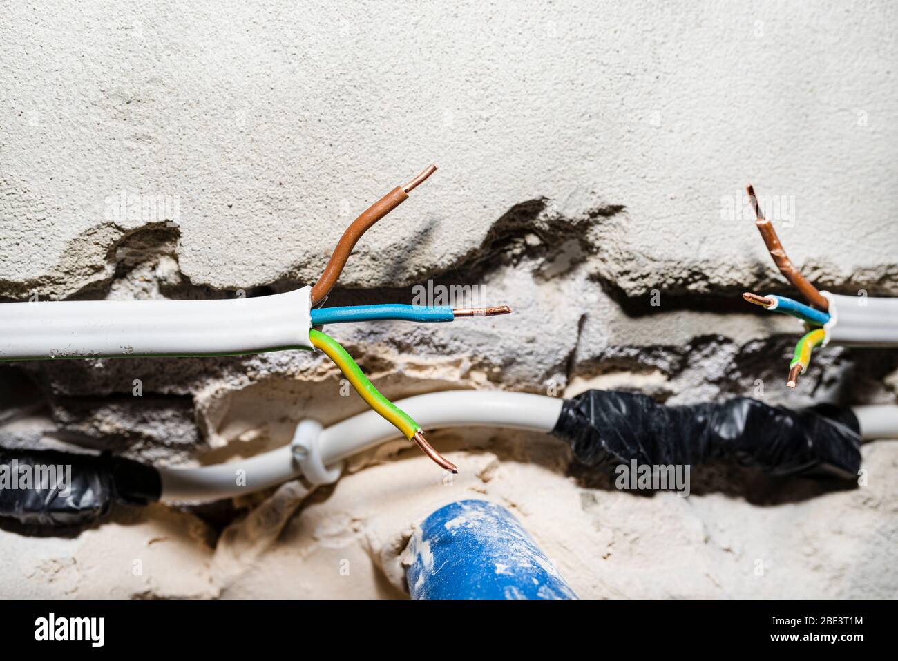 Cut single-phase cable in the wall of the house. Phase, neutral and ...
