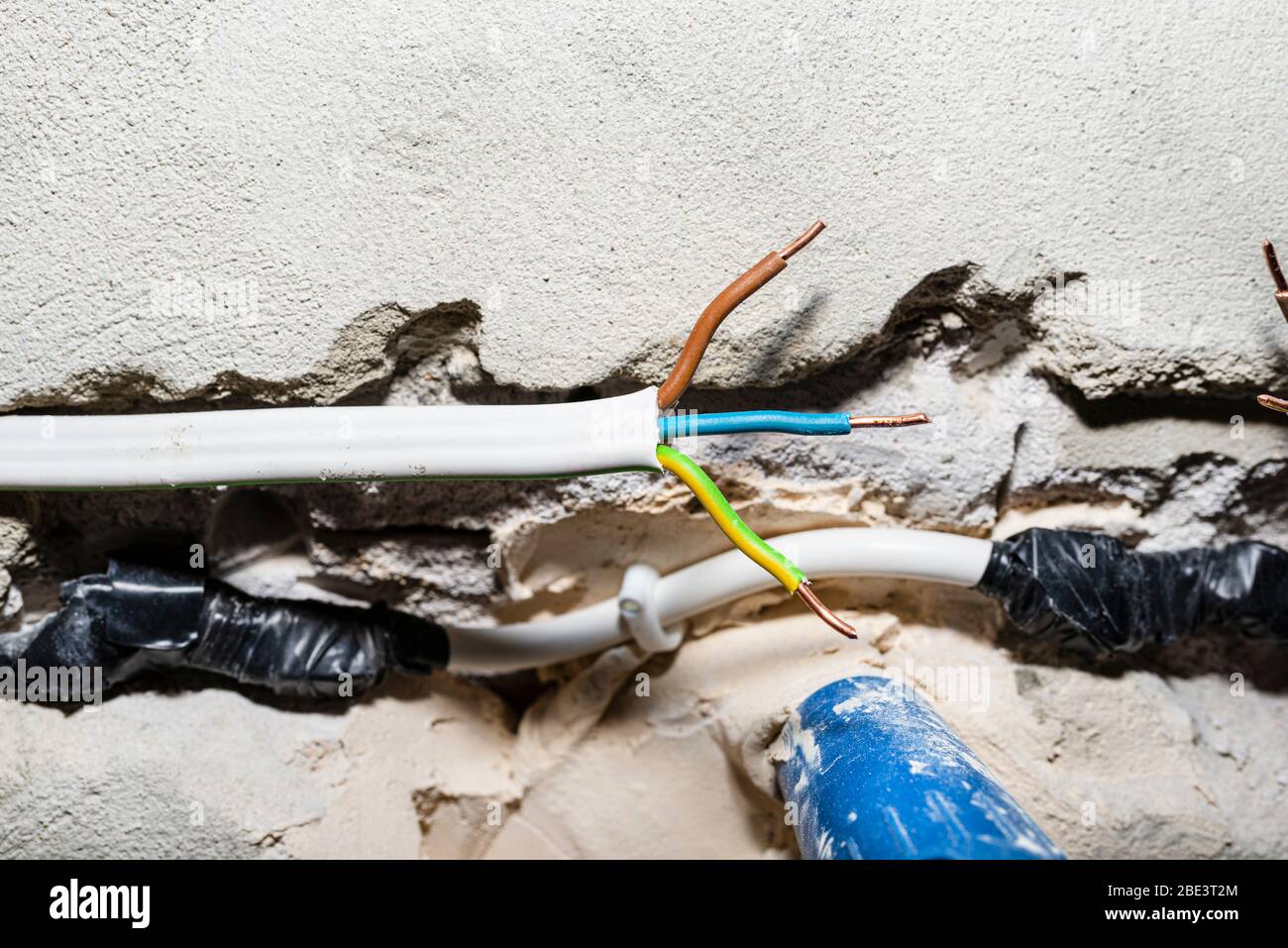 Cut single-phase cable in the wall of the house. Phase, neutral and ...