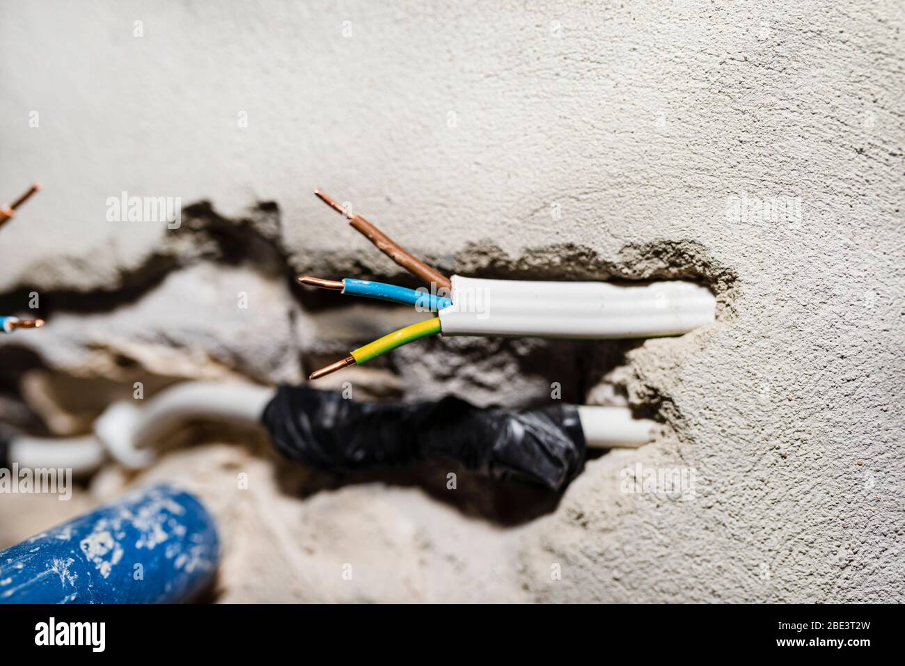 Cut single-phase cable in the wall of the house. Phase, neutral and ...