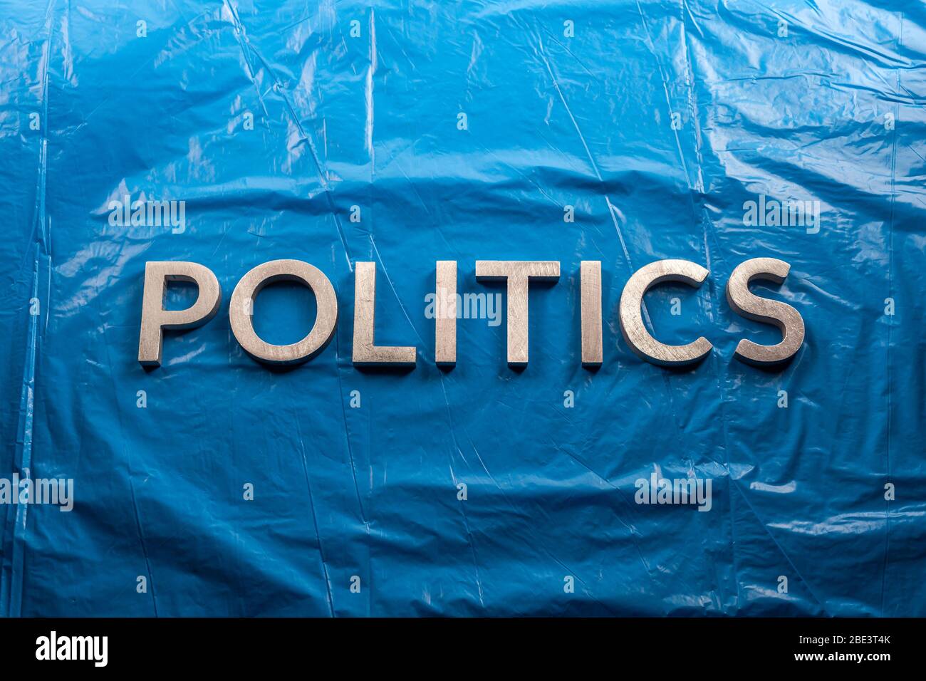 the word politics laid with silver aluminium letters over crumpled ...