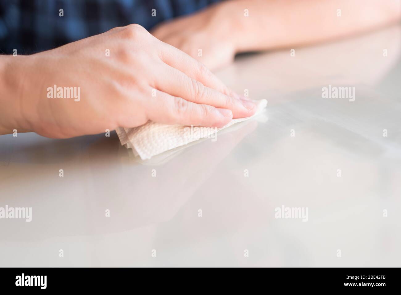 Hands cleaning an acetate. Process of making a homemade protective mask ...