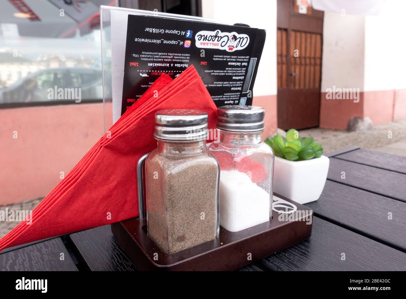 Outdoor table at the Al Capone restaurant with salt and pepper, napkins ...