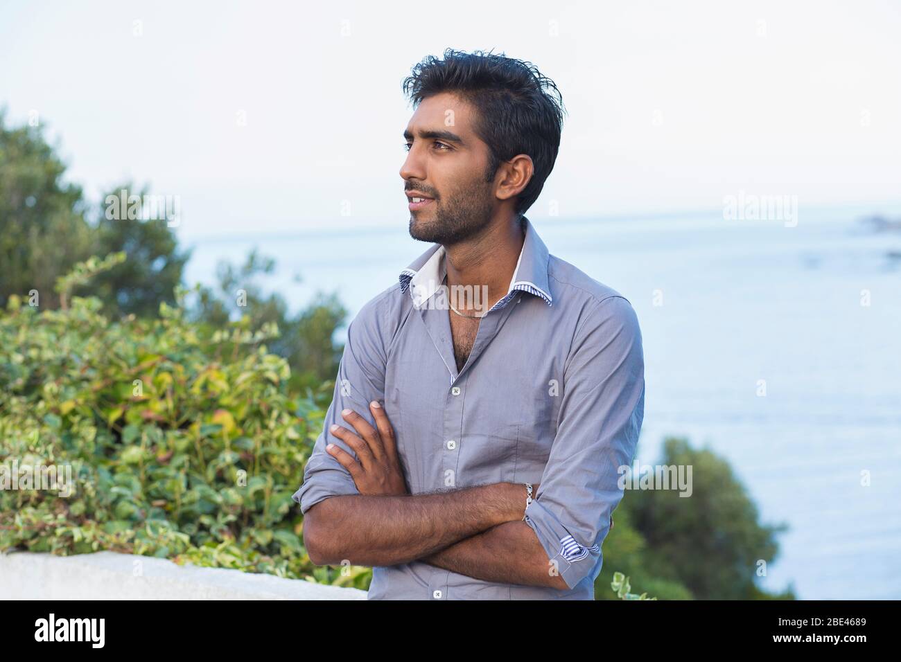 Young Indian business Man thinking isolated outdoors green trees blue ...