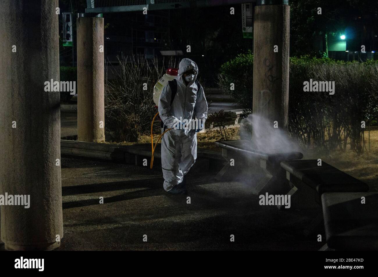 Cleaning staff on foot disinfect a square and streets. Day of night ...