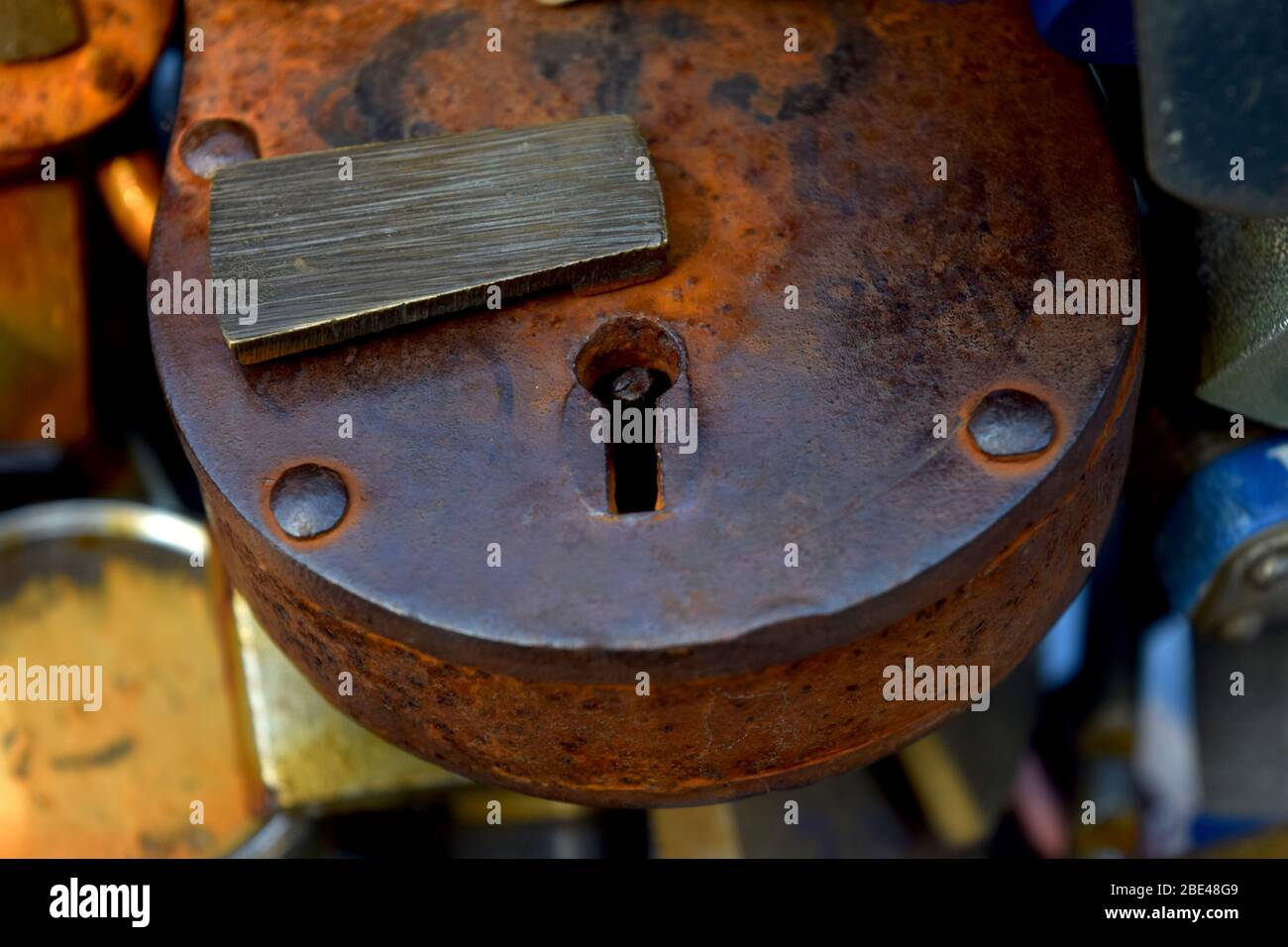 Close up of a rusty padlock with other metal locks in the background ...