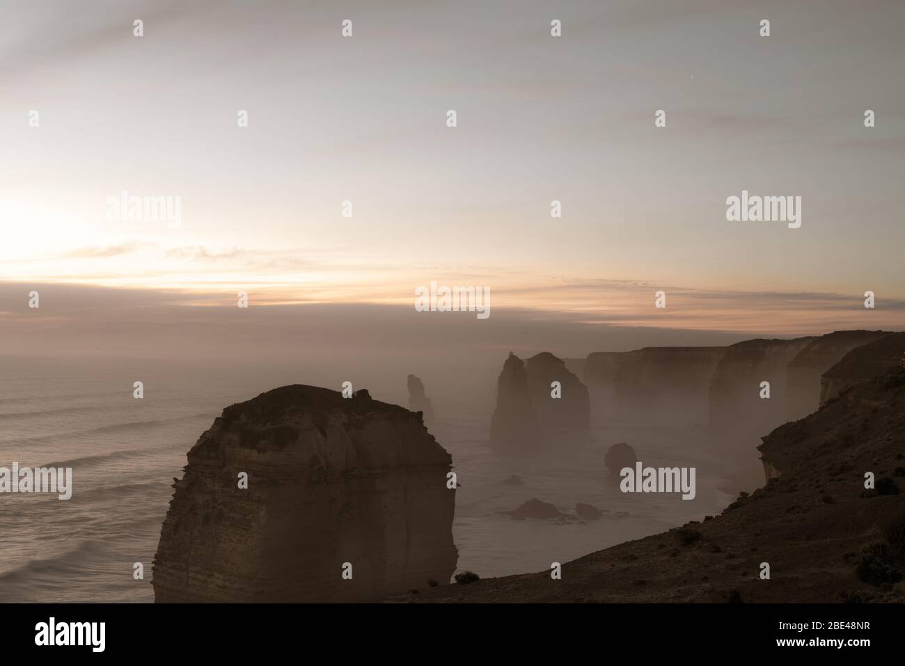 Twelve Apostles collection of limestone stacks at sunset in misty aged ...