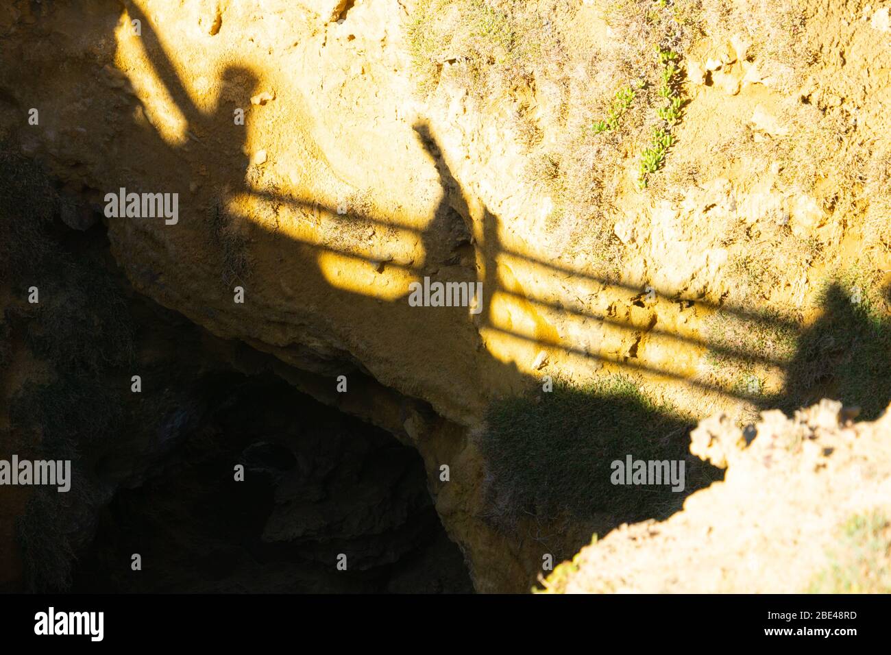 Shadow pattern of railing and people walking down to The natural arch ...