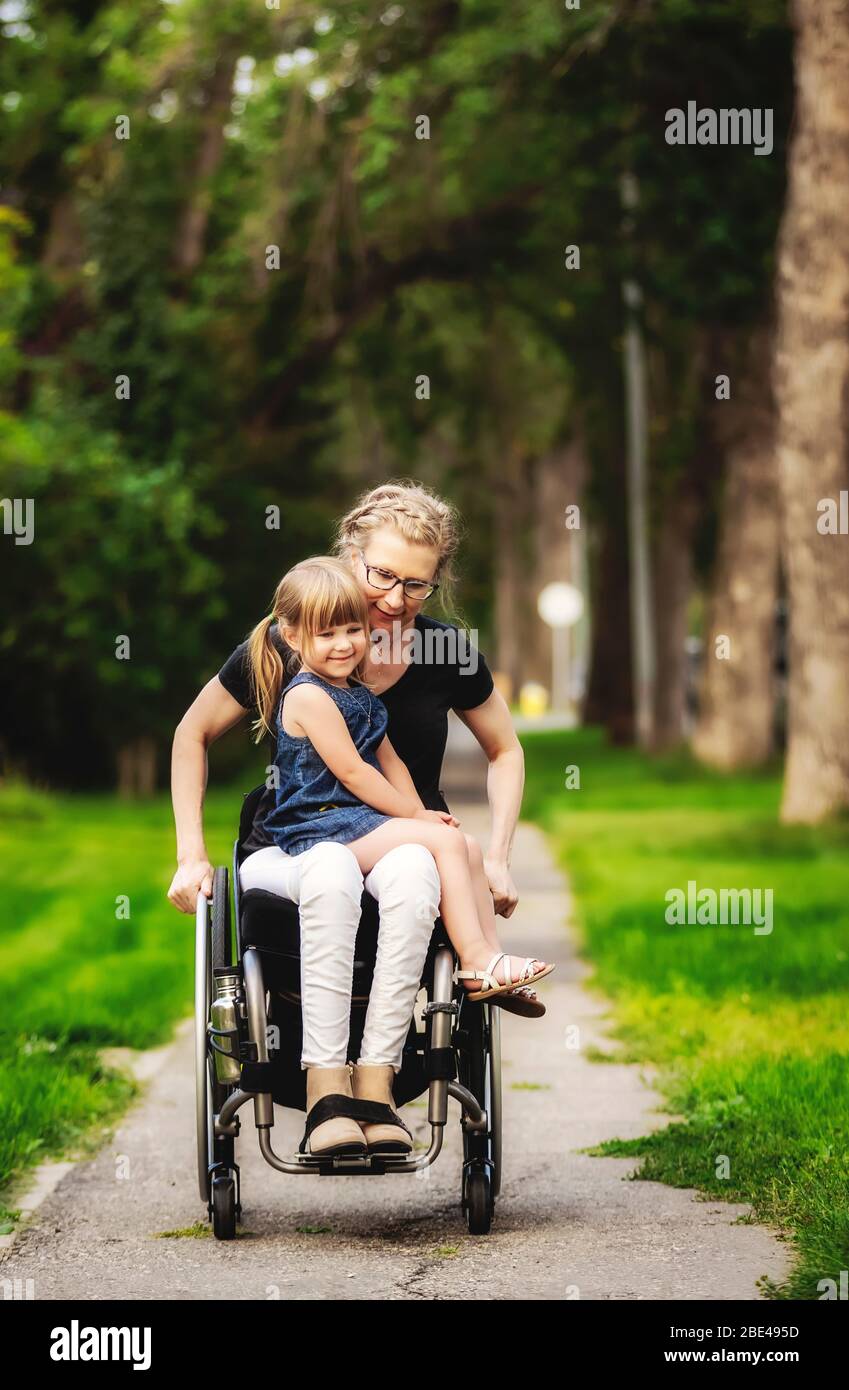 A paraplegic mom holding her little girl in her lap while taking her ...