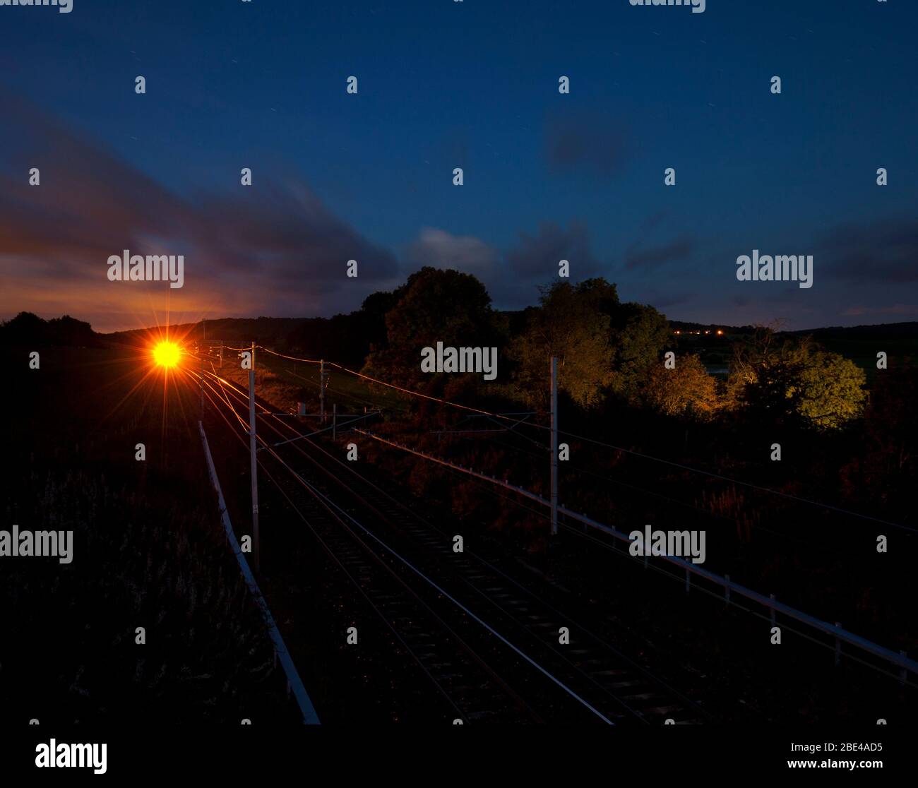 Yellow railway signal on the west coast mainline illuminating the track ...