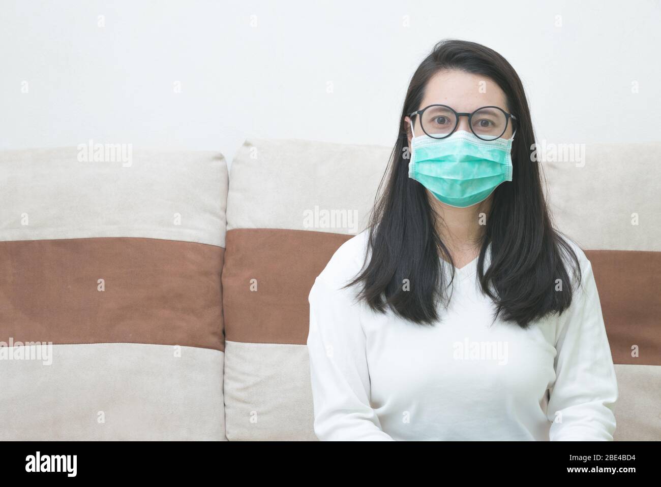 Young beautify woman wearing green doctor mask against white background ...