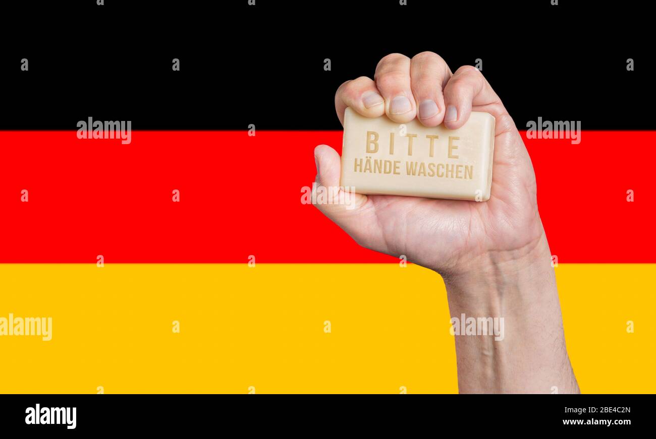 Caucasian male hand holding a bar of soap with words: Bitte Hande ...