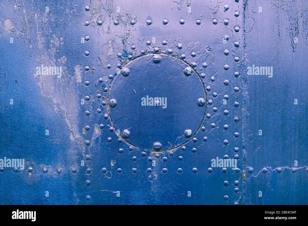 Closeup fragment of old aircraft skin painted in blue with rivets and ...