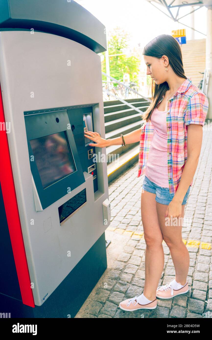 Young woman uses a vending machine for transport tickets Stock Photo ...