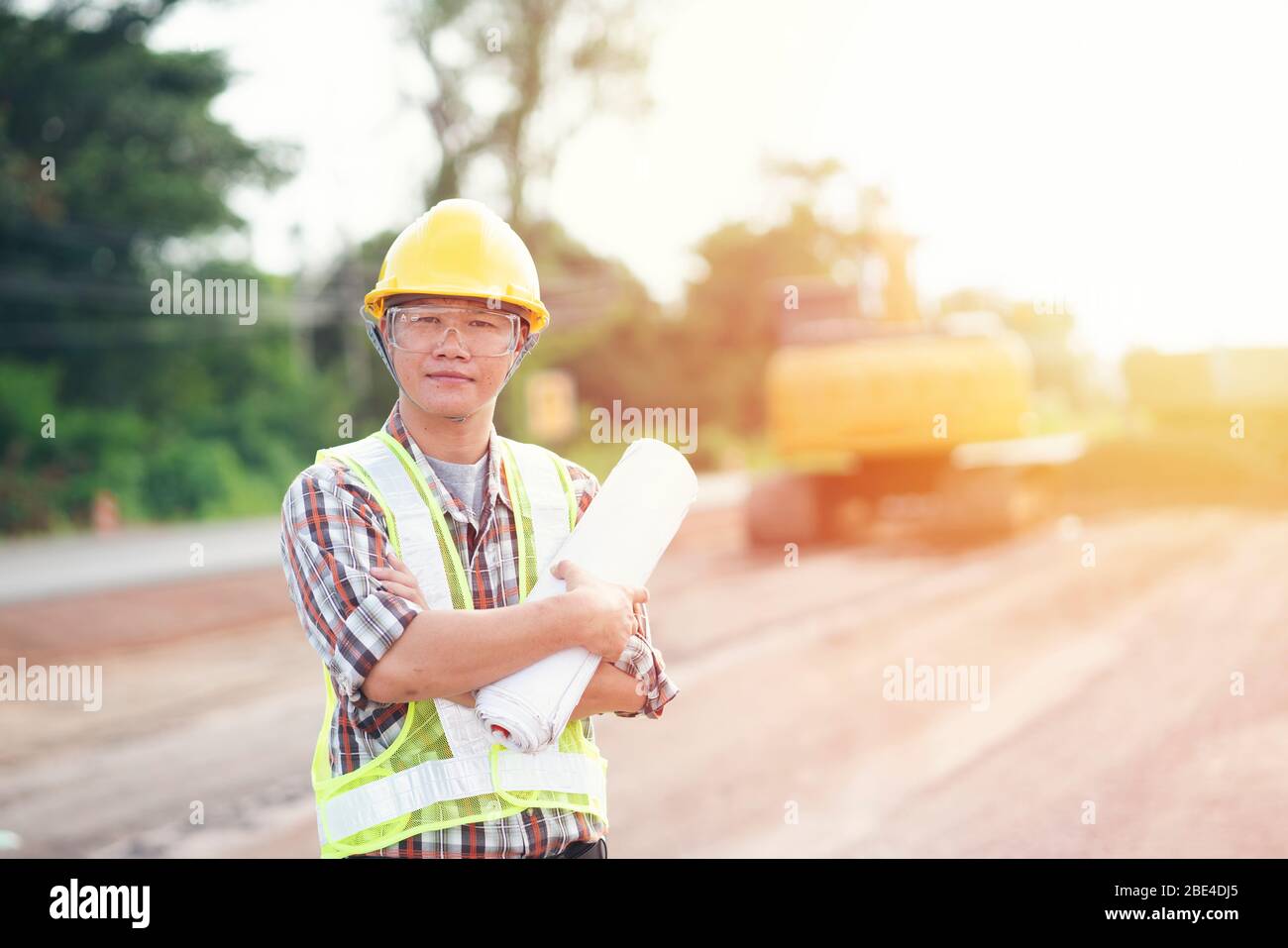 Engineer holding blueprint in construction site Stock Photo - Alamy