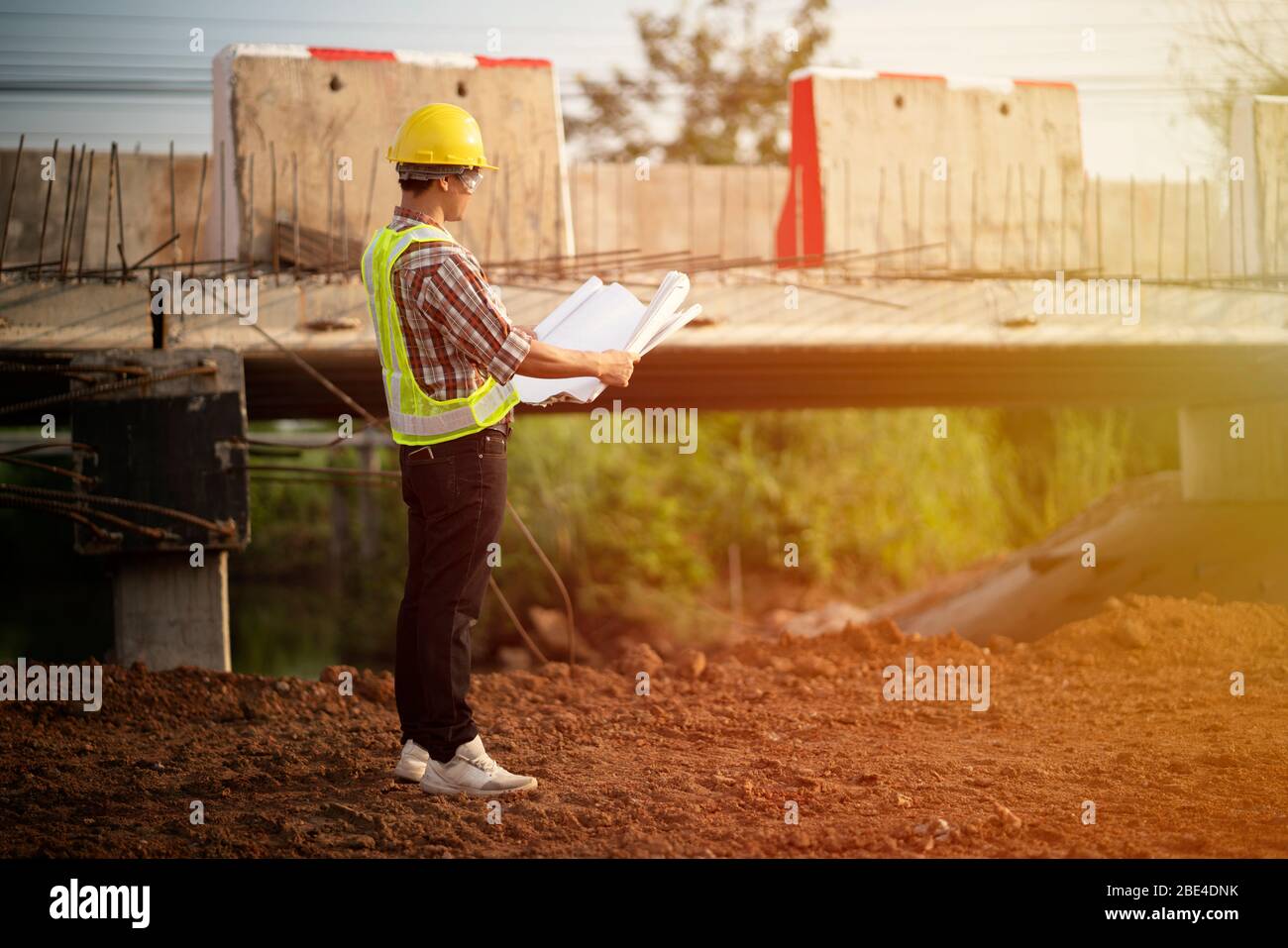 Engineer wear a hard helmet and holding blueprint at construction site ...