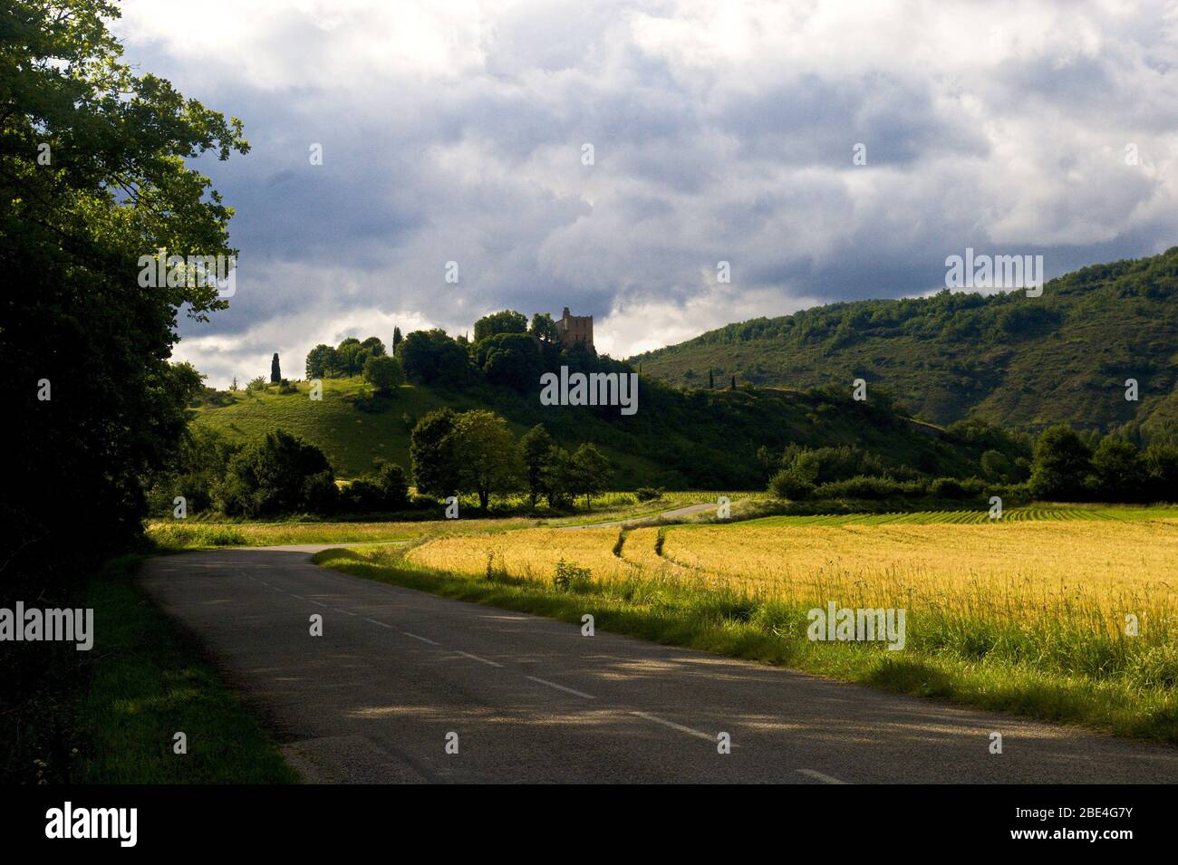 Road passing through a pretty French landscape with clouds overhead yet ...