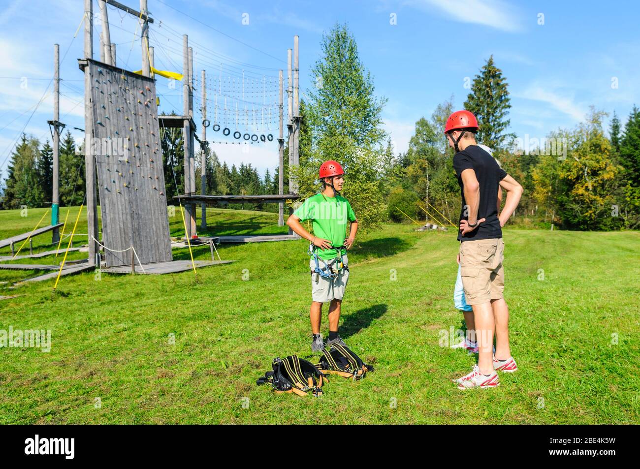 Preparing for climbing exercises in high ropes park with an instructor ...