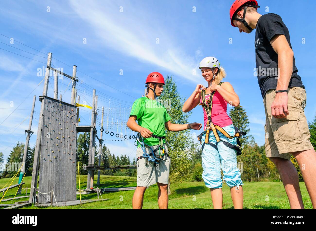 Preparing for climbing exercises in high ropes park with an instructor ...