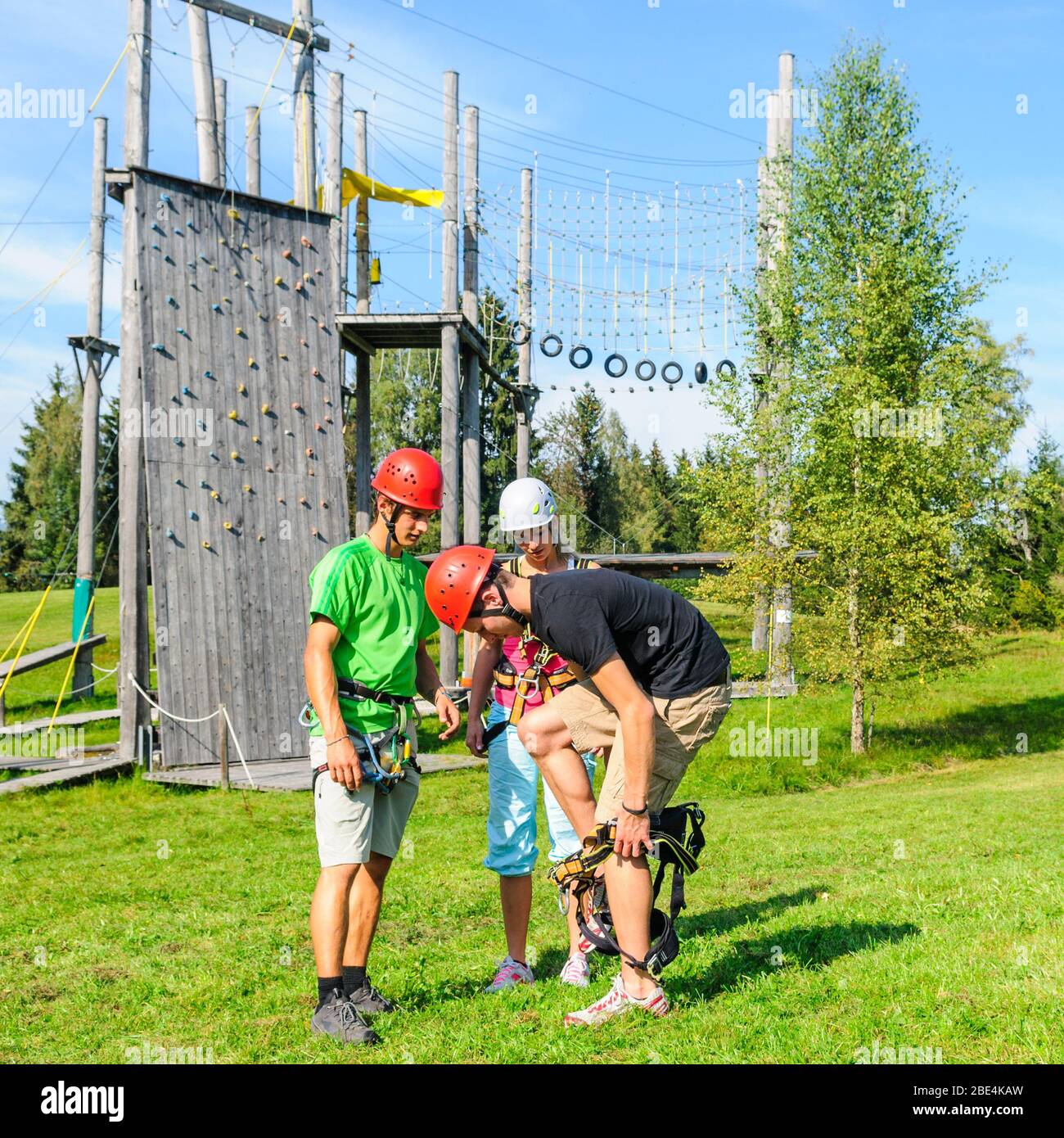 Preparing for climbing exercises in high ropes park with an instructor ...