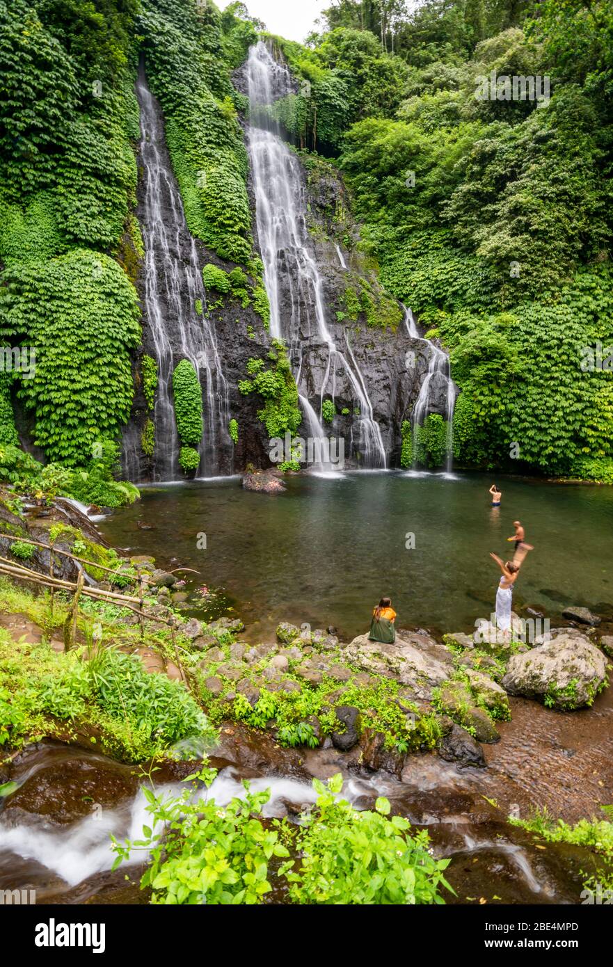 Vertical view of tourists enjoying the Banyumala Waterfalls in Bali ...