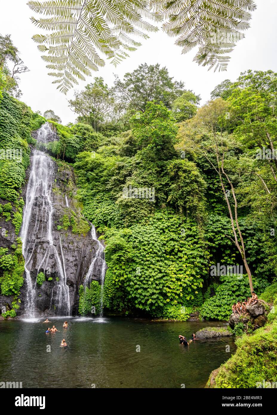 Vertical view of tourists enjoying the Banyumala Waterfalls in Bali ...
