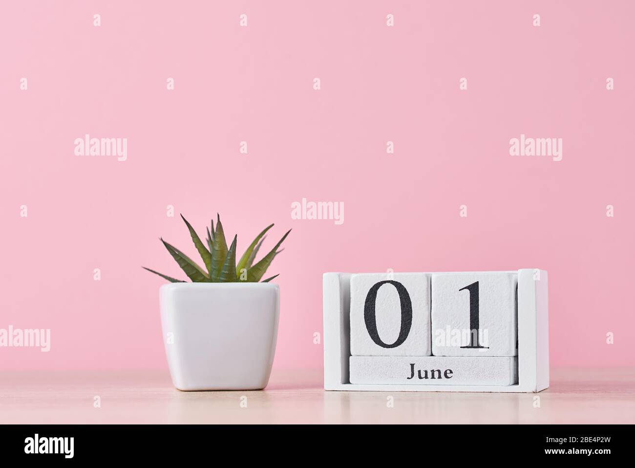 Wooden block calendar with date June 1 and succulent plant in pot on ...