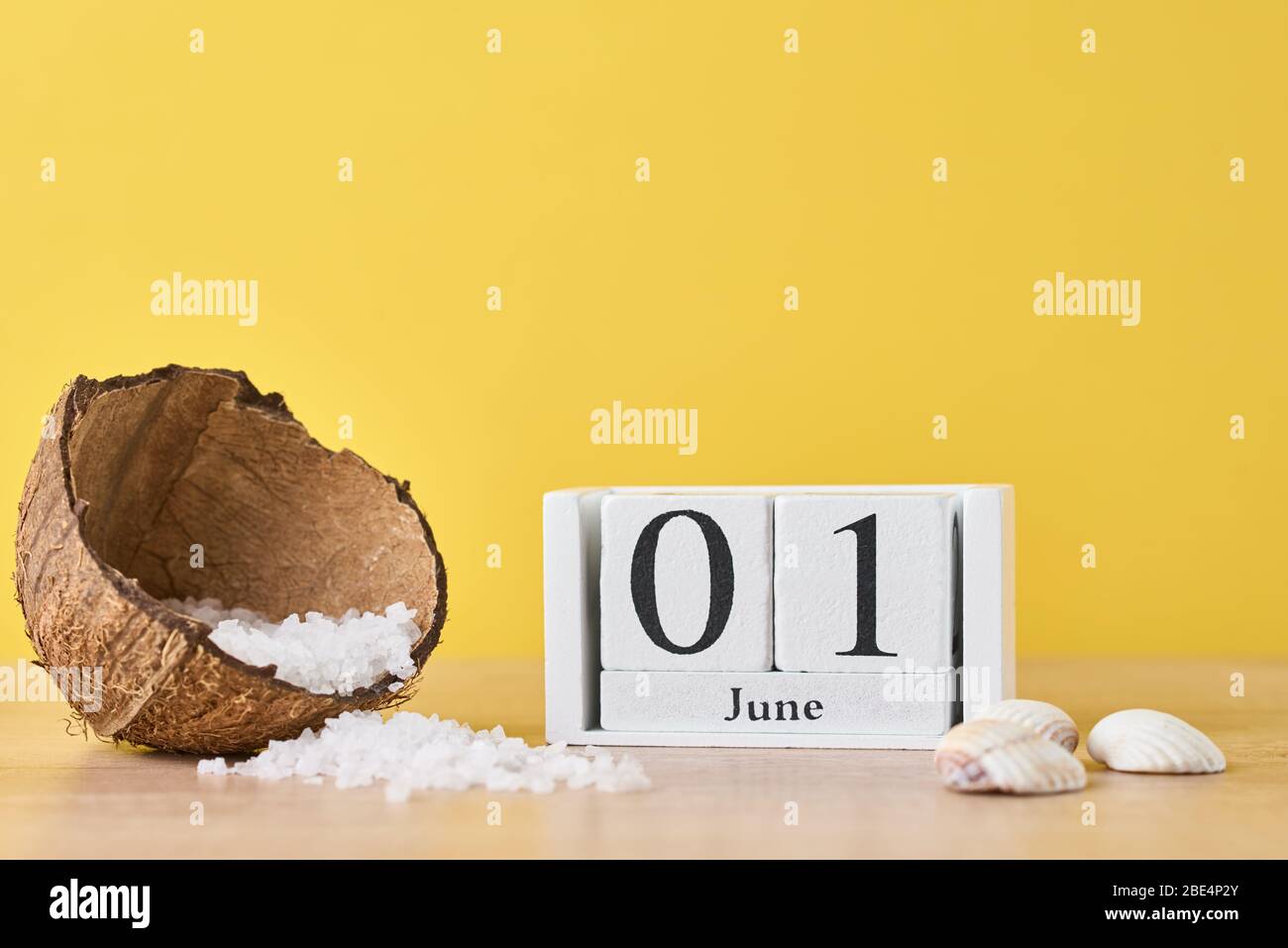 Wooden block calendar with date June 1 and coconut with sea salt on ...