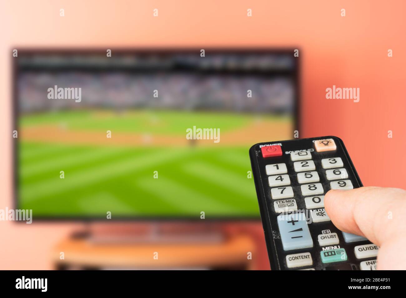 Caucasian man watching baseball game on TV at home. Changing channels ...