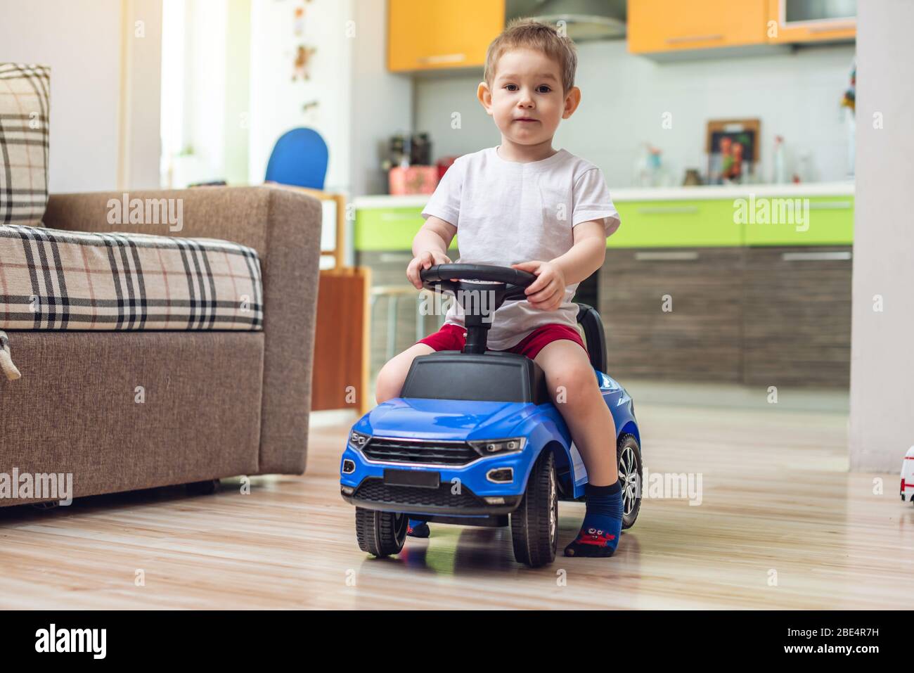 Happy little boy drive on a toy car in the flat. Activity for a child ...