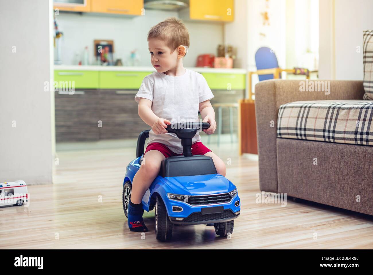 Happy little boy drive on a toy car in the flat. Activity for a child ...