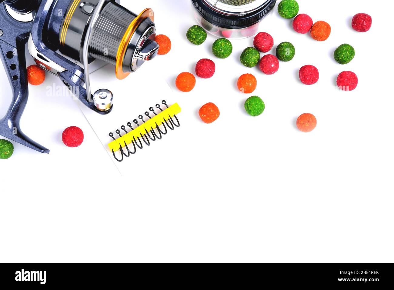 Fishing coil, colored boilies, braided cord, on white background, close ...