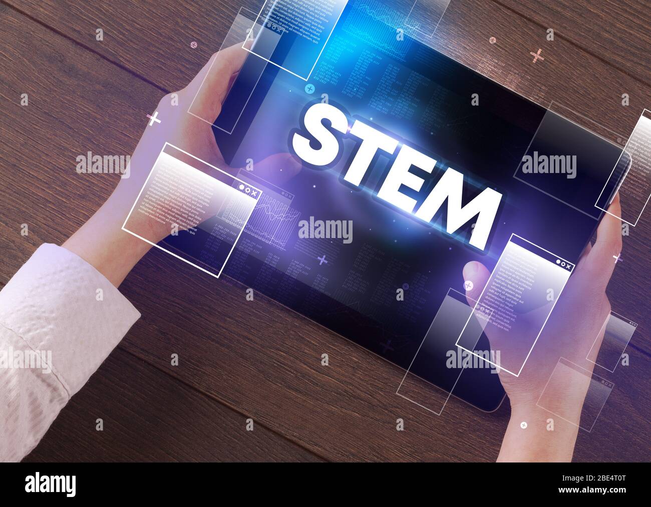 Close-up of a hand holding tablet with STEM abbreviation, modern ...