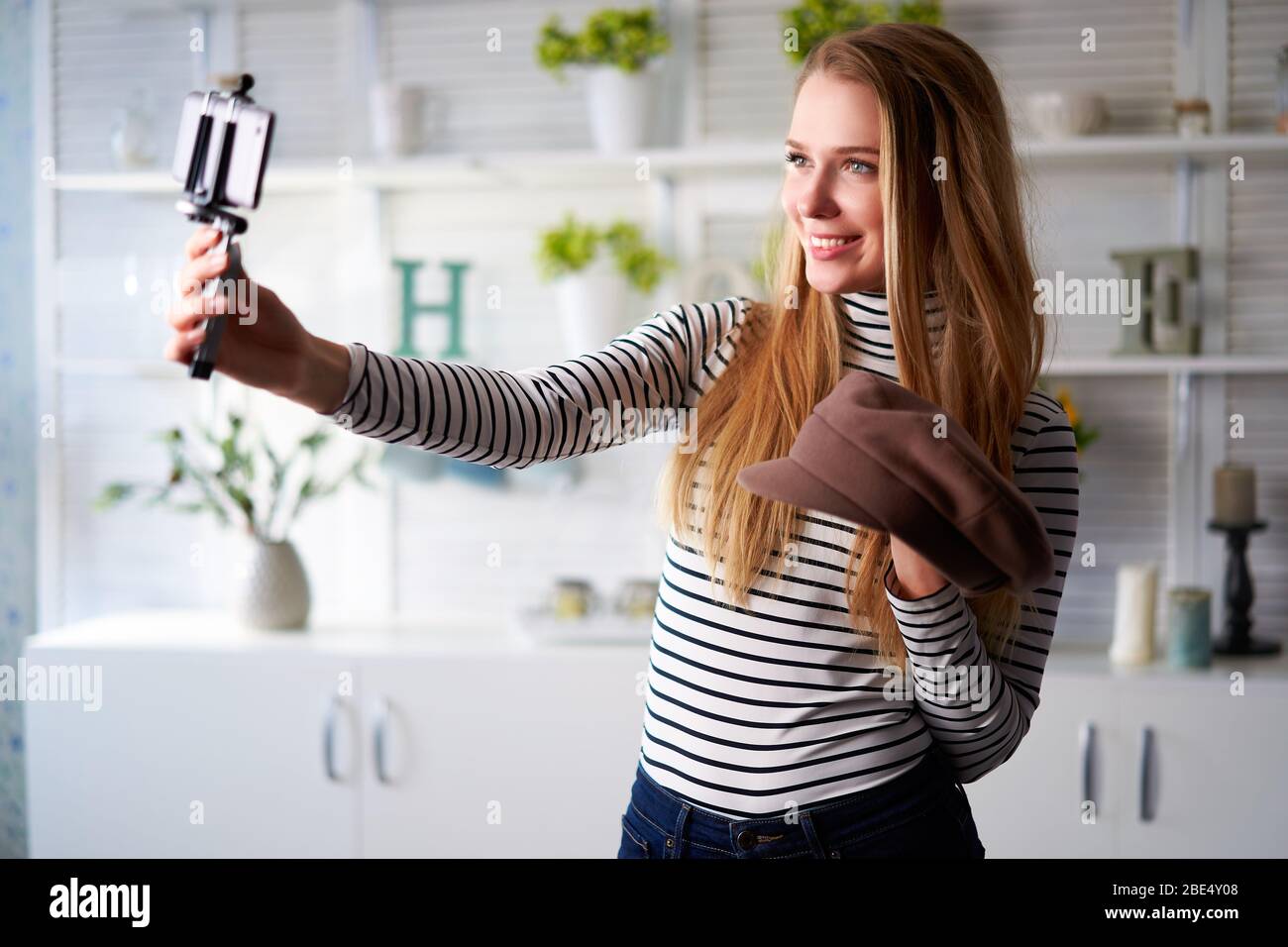 Fashion blogger woman in jeans and turtleneck showing fashionable caps ...