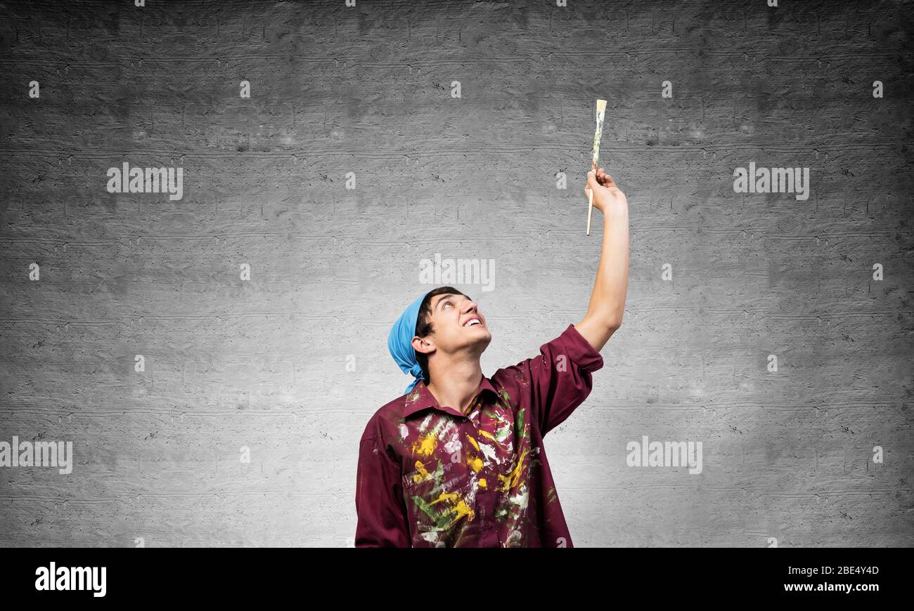 Young painter artist pointing upwards Stock Photo - Alamy