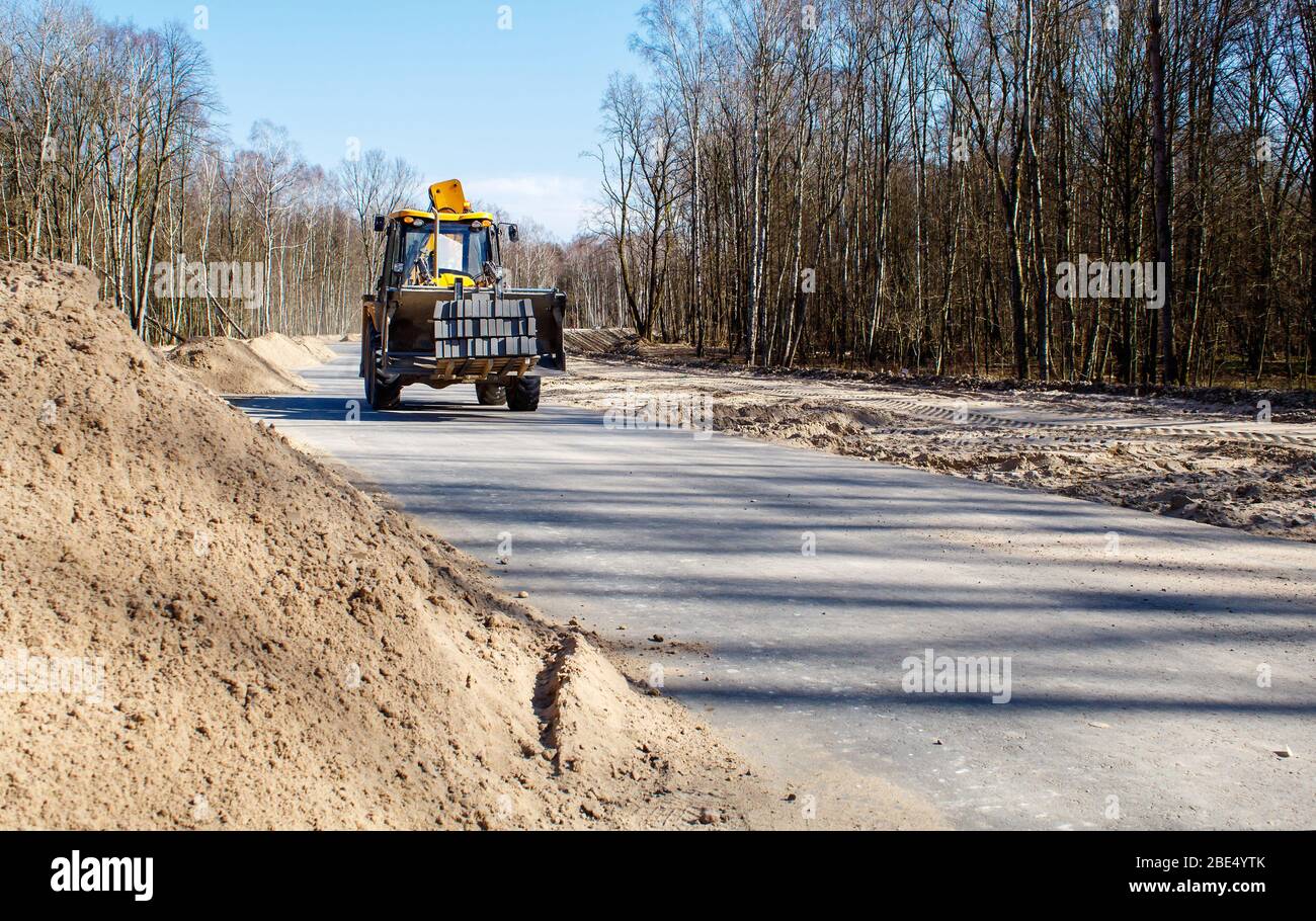 construction of a new modern road in the forest on sunny spring day ...