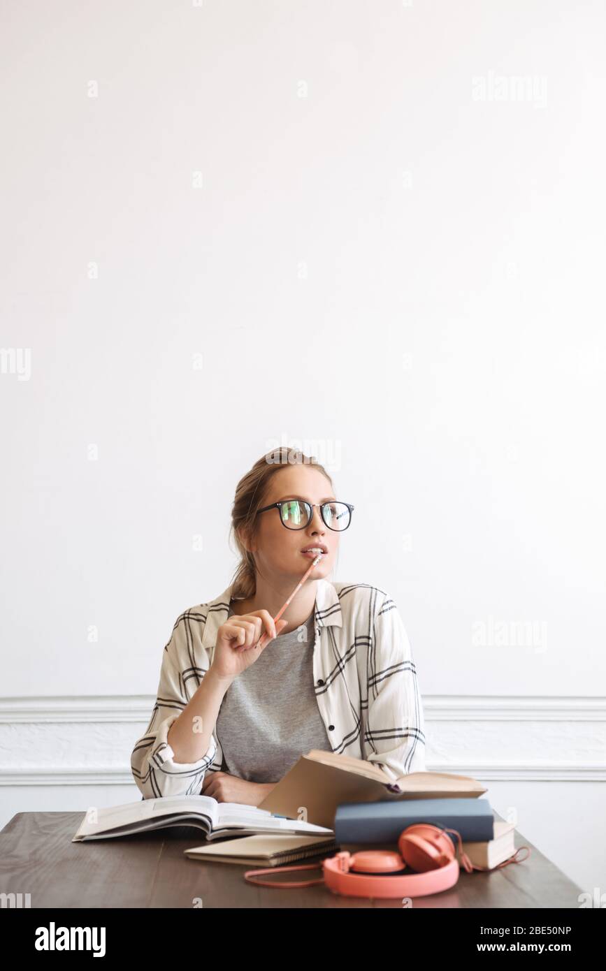 Attractive young girl student doing homework at the cafe indoors ...