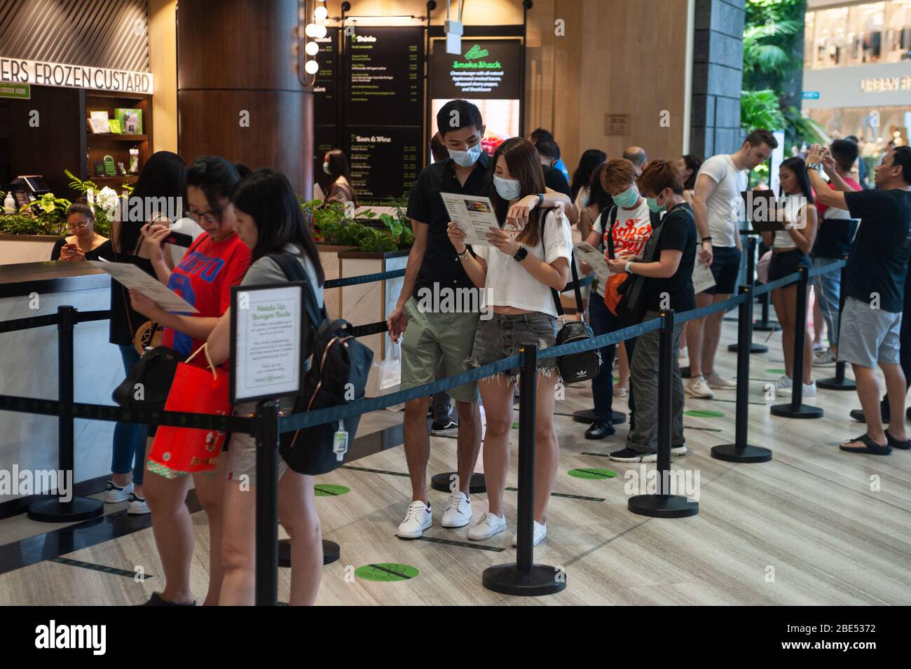 28.03.2020, Singapore, Republic of Singapore, Asia - Customers queue in ...