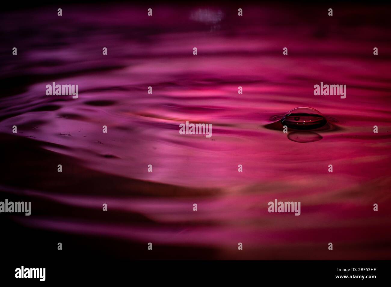 purple splash in to the water Stock Photo - Alamy