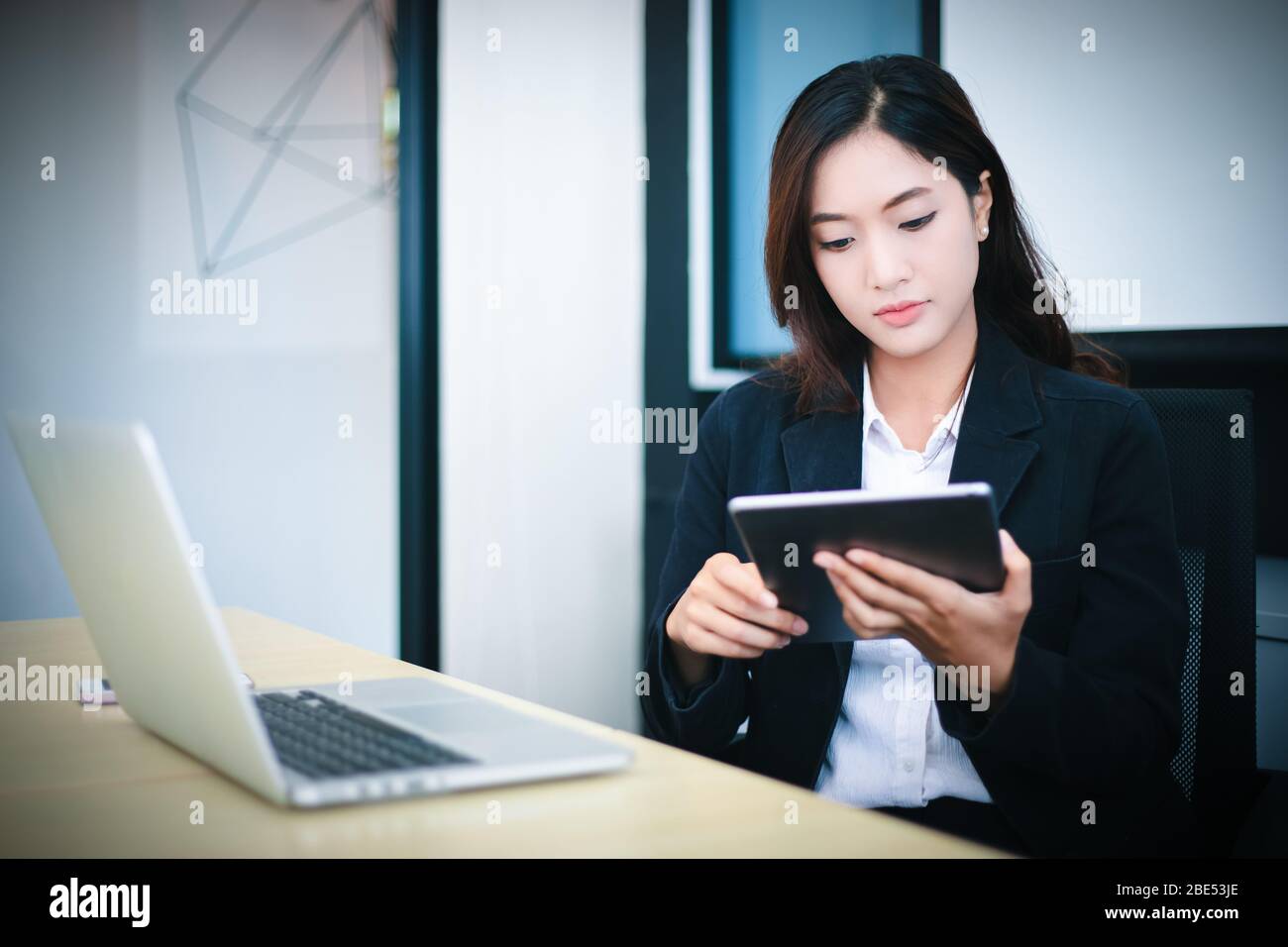 Asian business women using tablet for working at office relax time and ...