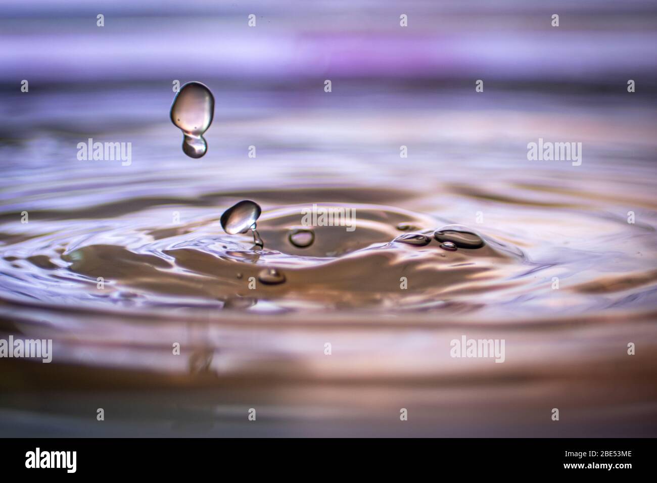 purple splash in to the water Stock Photo - Alamy