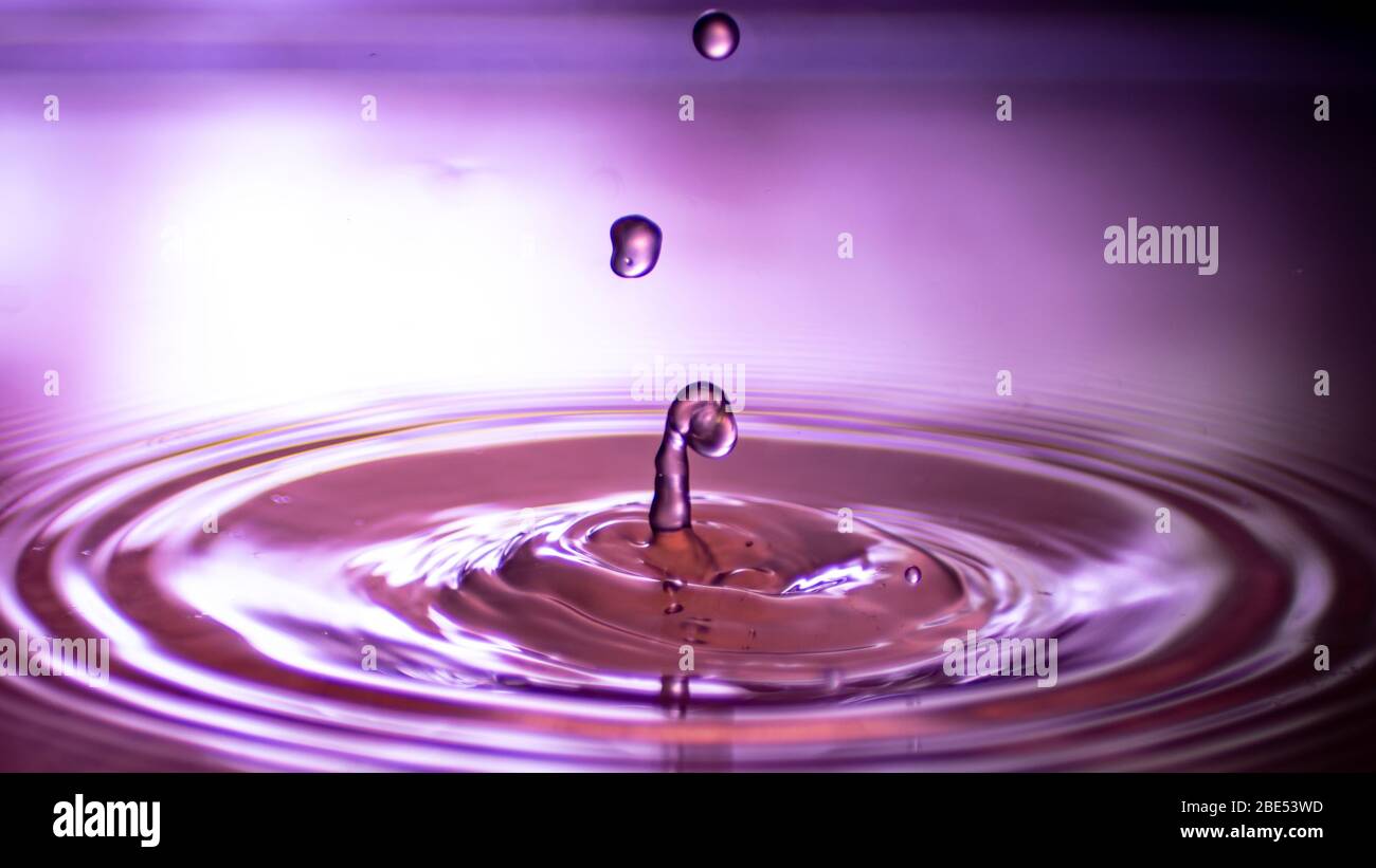 purple splash in to the water Stock Photo - Alamy